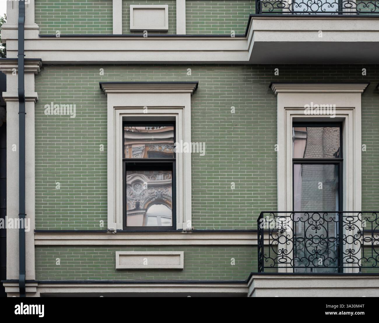 Part of old building facade. Building with green tiled facade and beige ...