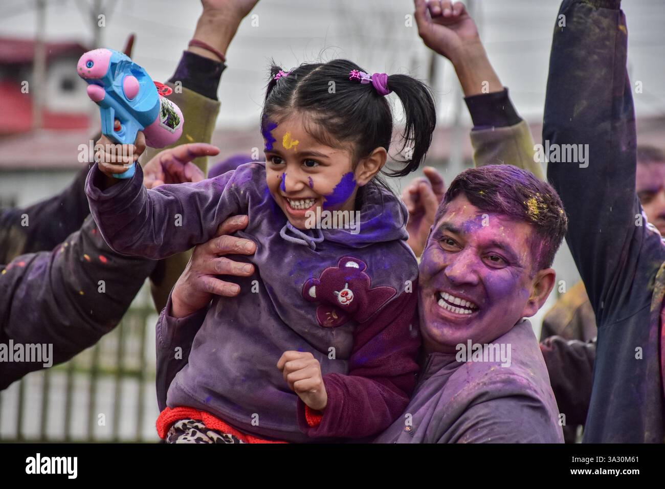 Srinagar, India. 14th Mar, 2025. A Hindu girl (L) smeared in colored ...