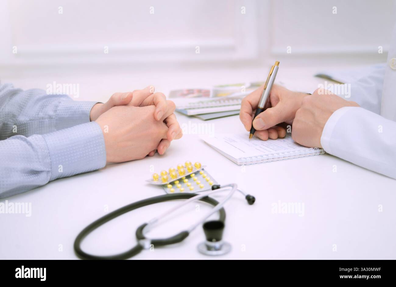 Doctor discusses health concerns with a patient, reviewing notes and ...