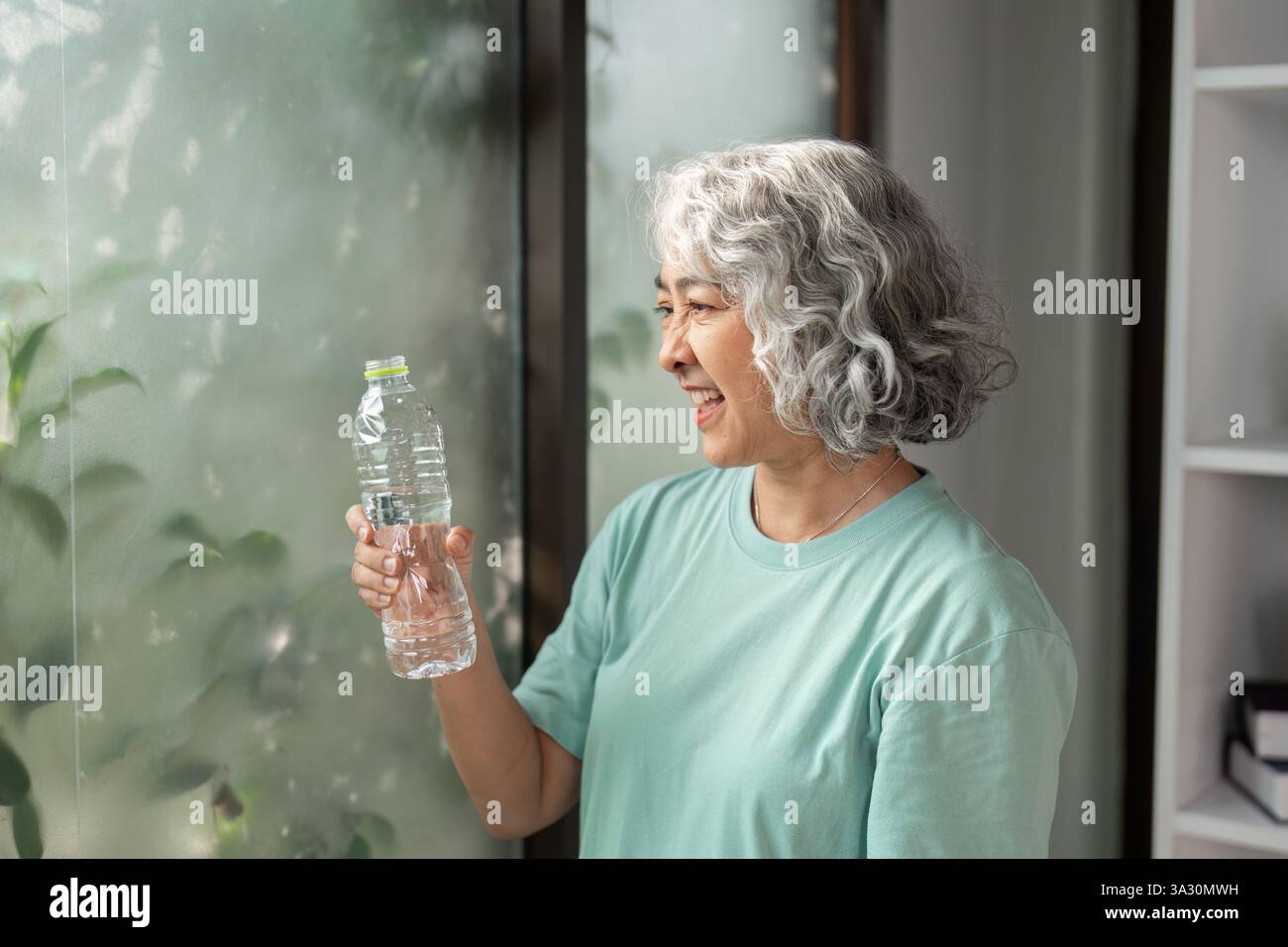Hydration and Health Awareness. An elderly woman smiling while holding ...