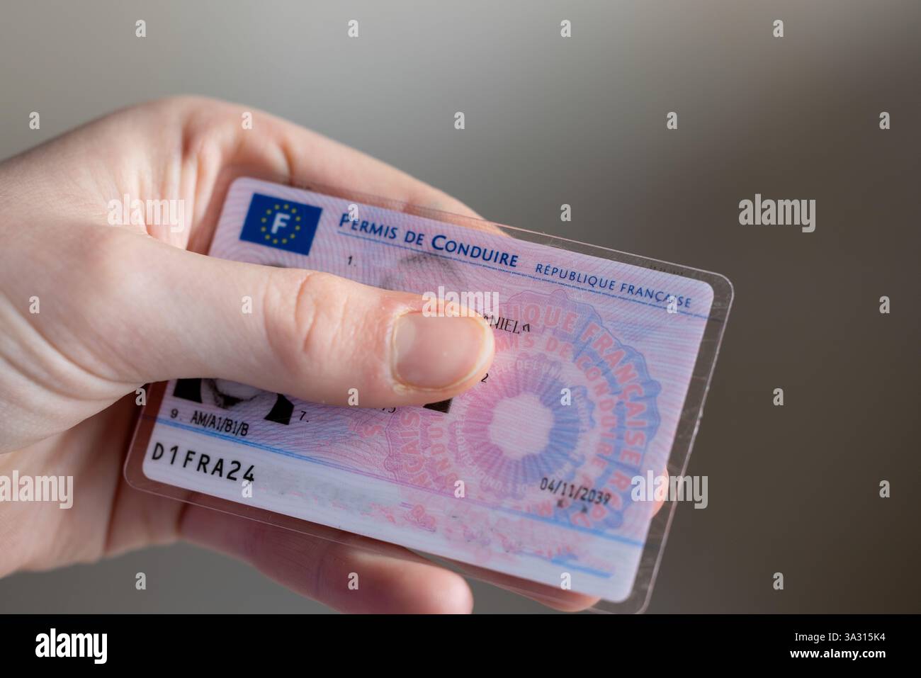 Paris, France - March 13, 2025 : Person holding their driver's license ...
