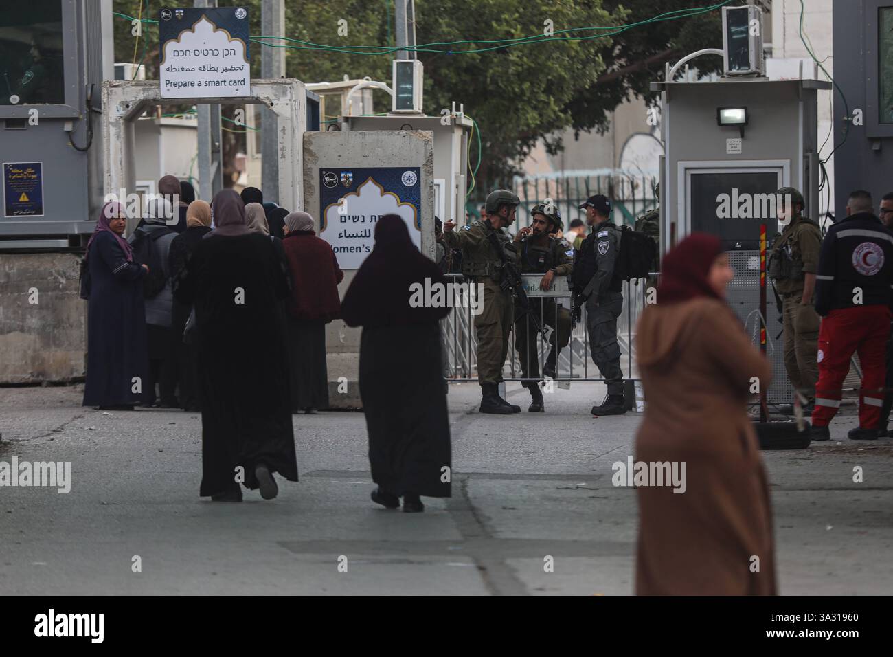 Palestinian Muslims wait in a line to cross an Israeli checkpoint in ...