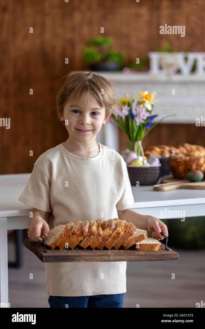 Cute preschool child, boy, holding sweet brioche bun for Easter ...
