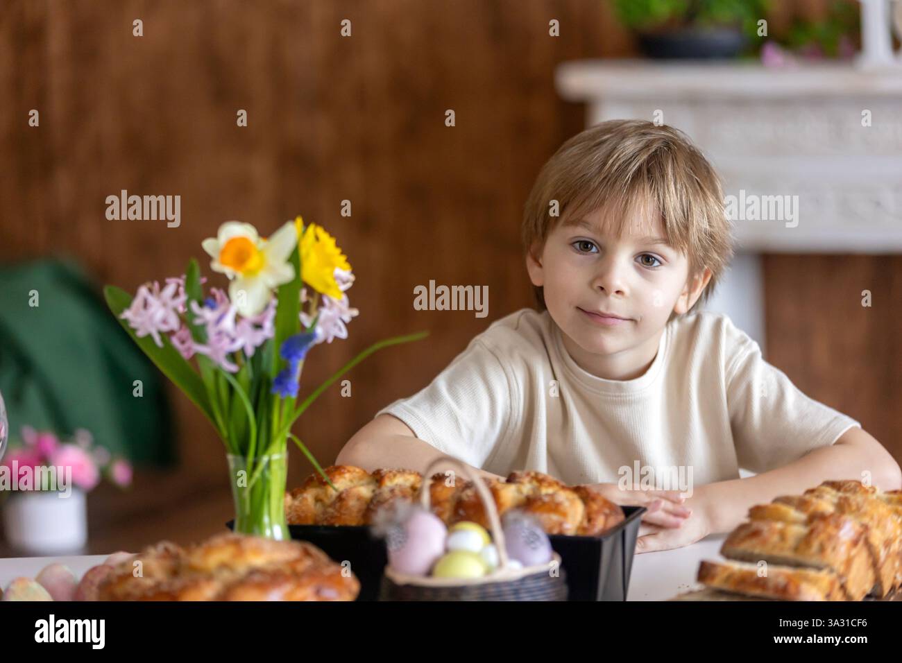 Cute preschool child, boy, holding sweet brioche bun for Easter ...