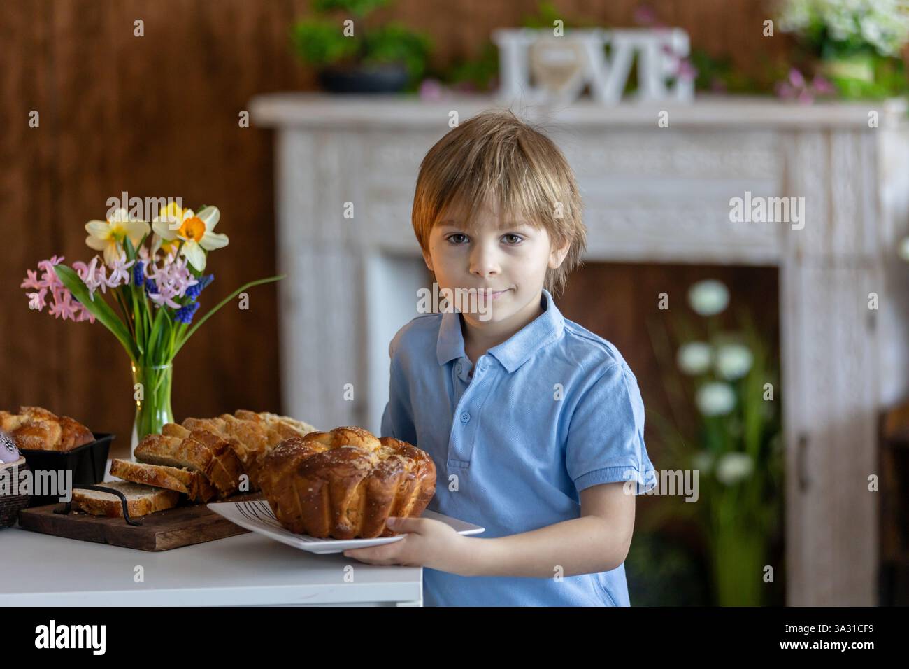 Cute preschool child, boy, holding sweet brioche bun for Easter ...