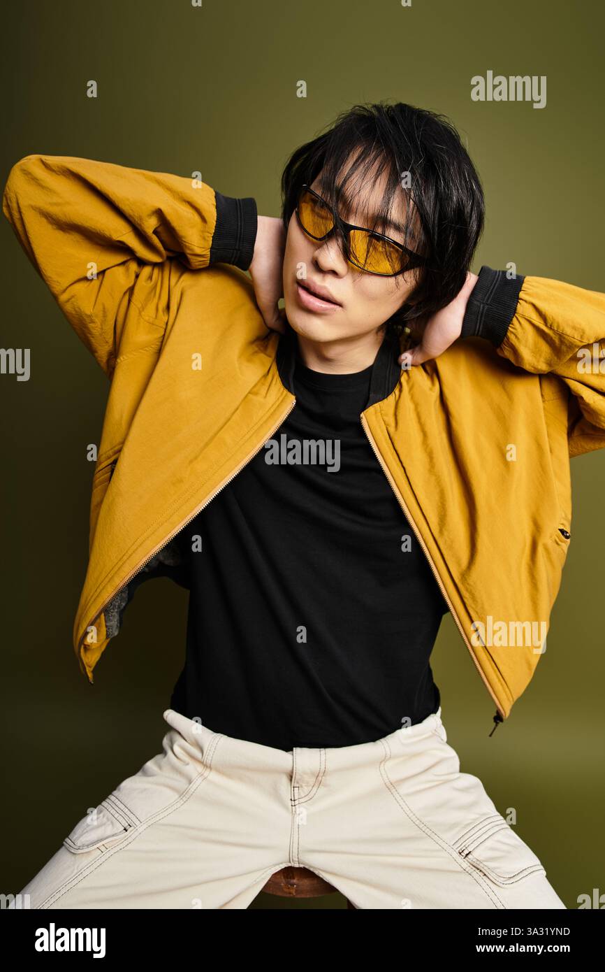 A young asian man showcases modern fashion in a studio, exuding ...