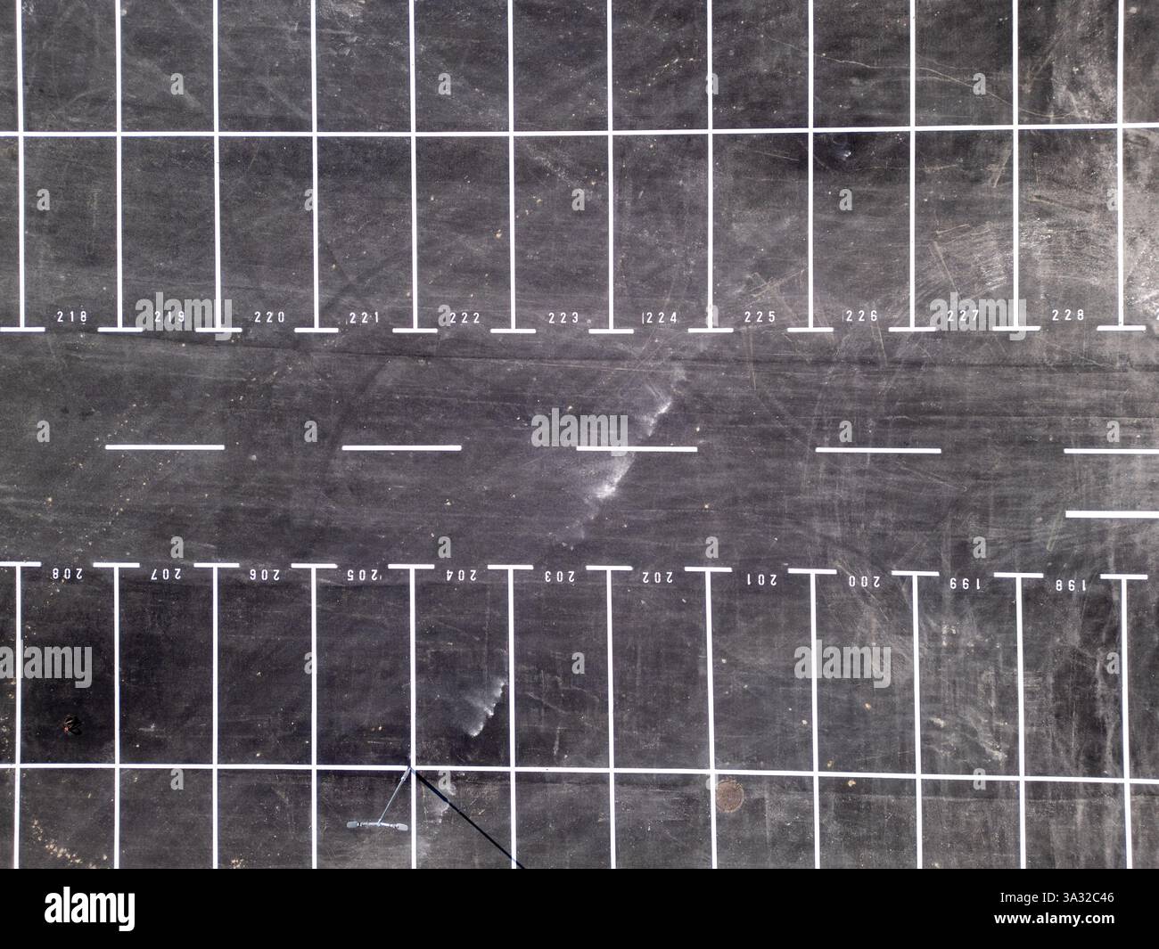Aerial view of an empty parking lot with clearly marked spaces and road ...
