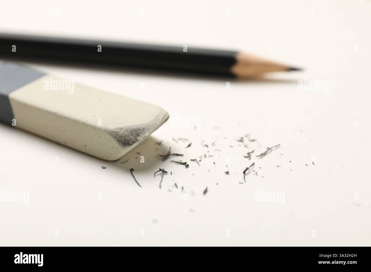 Eraser, pencil and scraps on white sheet of paper, closeup Stock Photo ...