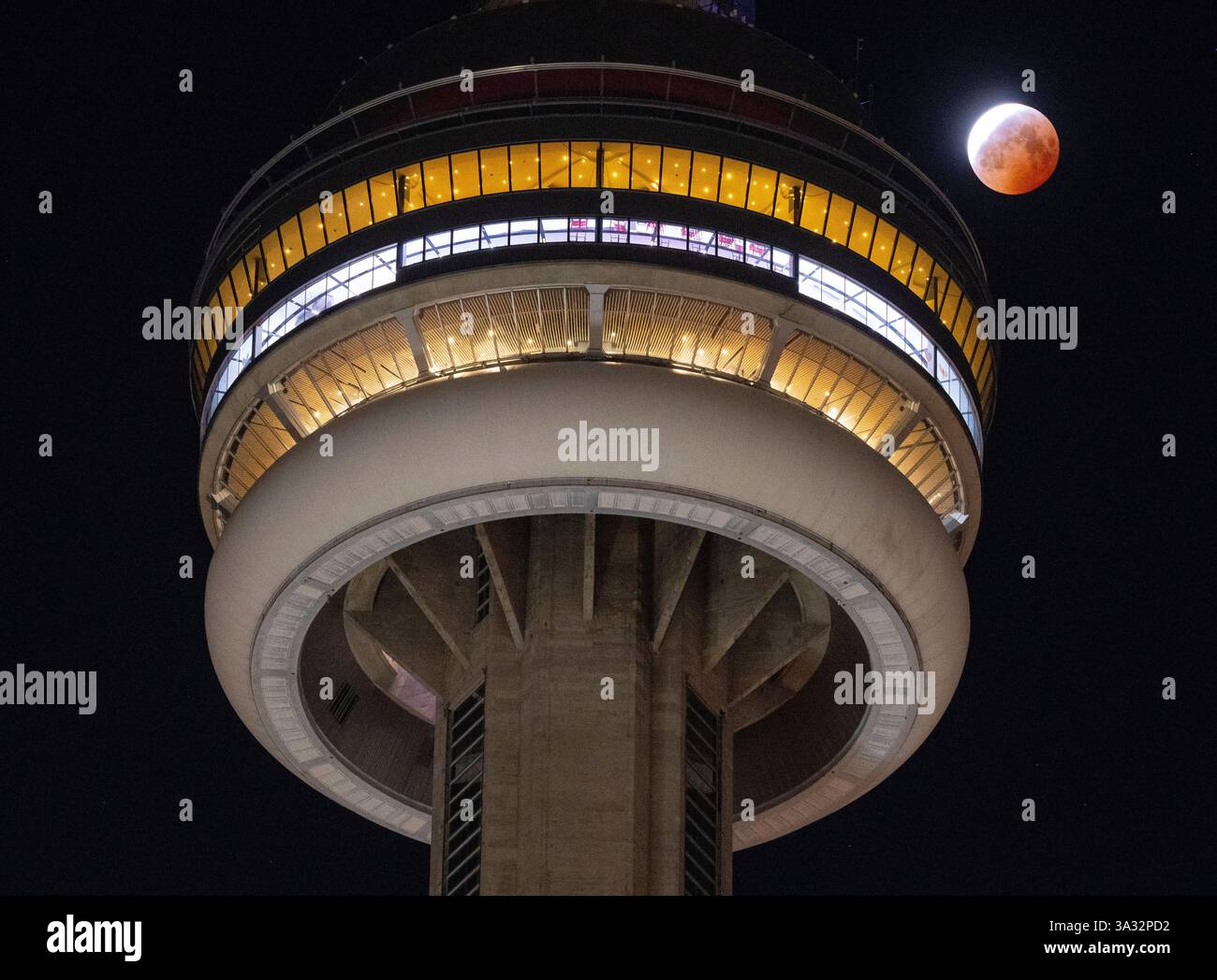 The blood moon lunar eclipse is seen behind the CN Tower in Toronto on Friday, March 14, 2025 ...