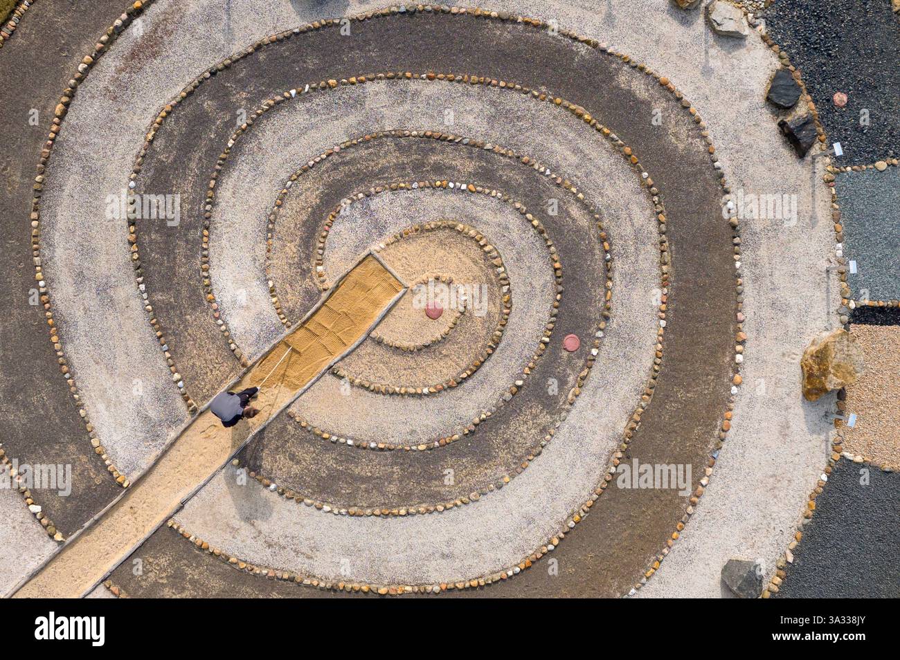 Boxberg, Germany. 14th Mar, 2025. A gardener works in the landscaped ...