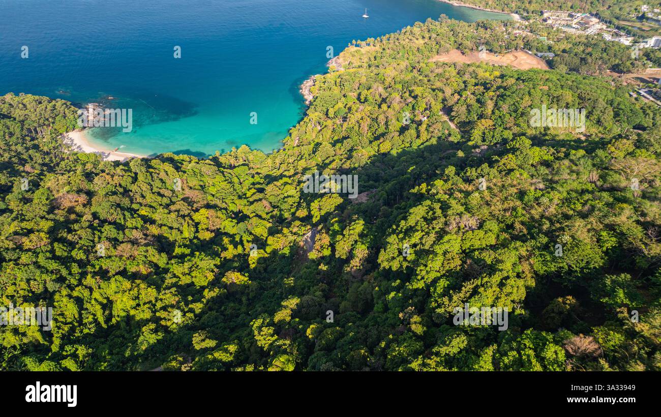 Forest shadows cast over the beach in the morning. A small white beach ...