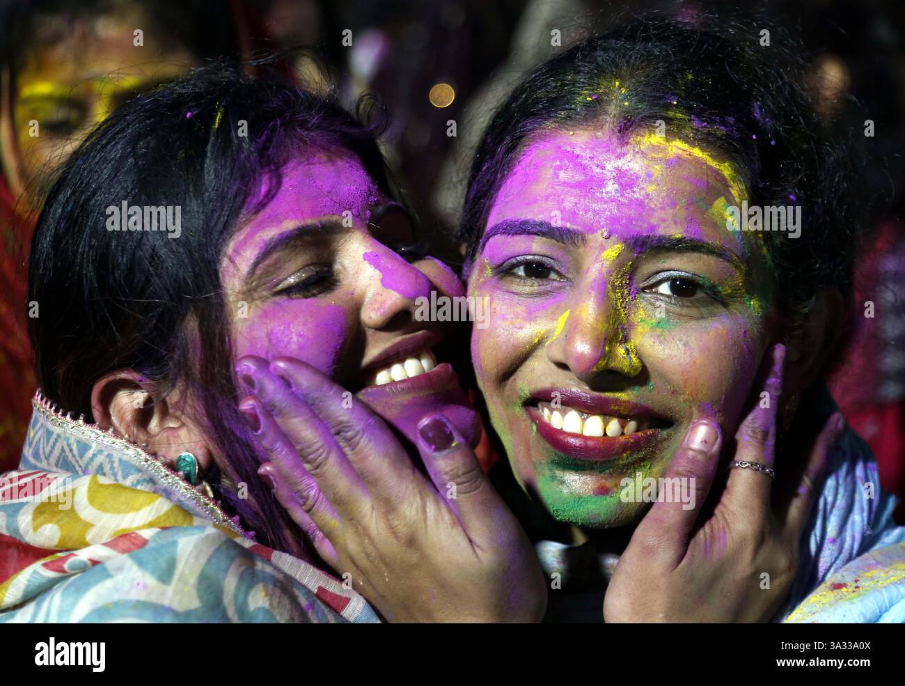 Karachi. 13th Mar, 2025. People smeared with colored powder celebrate ...