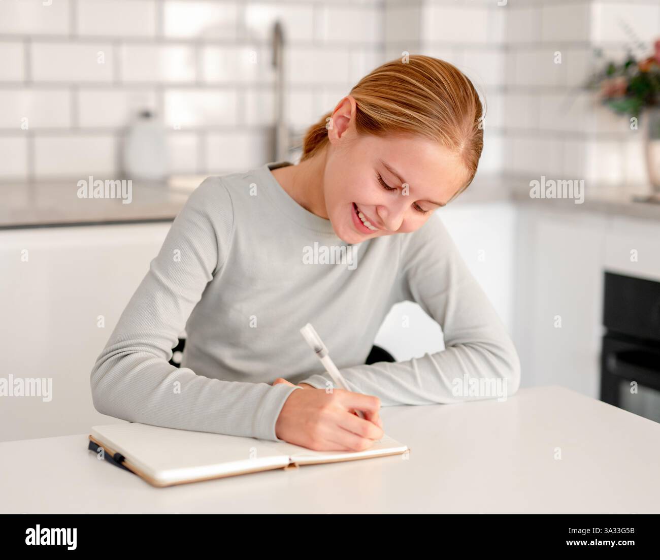Cute Little Girl Happily Doing Writing Homework Stock Photo - Alamy