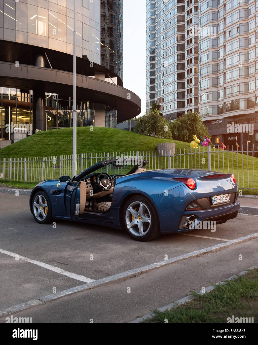 Blue Ferrari California with opened door. Cabriolet in parking lot near ...