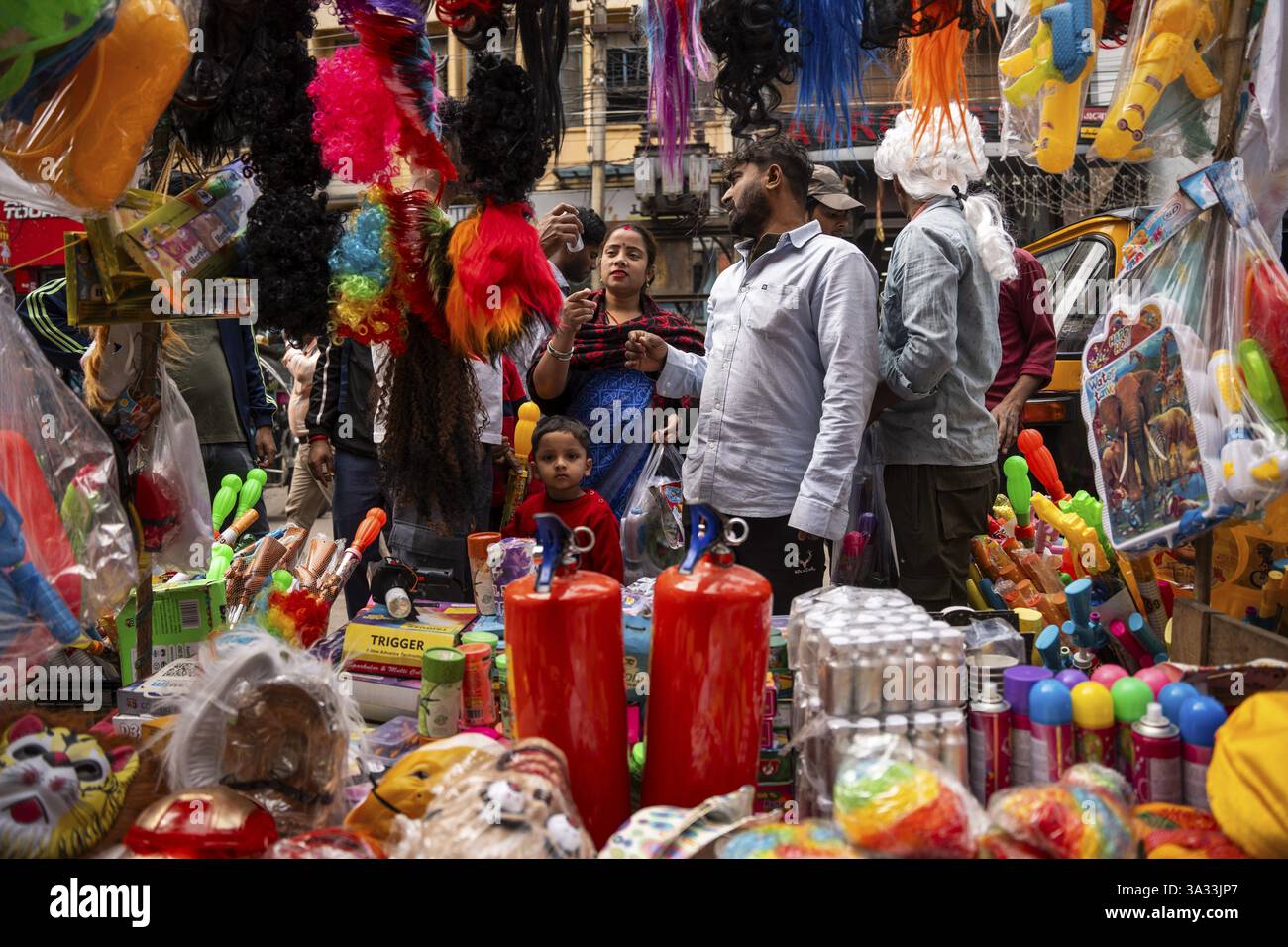 People buy Holi celebration items in a market on the eve of Holi ...
