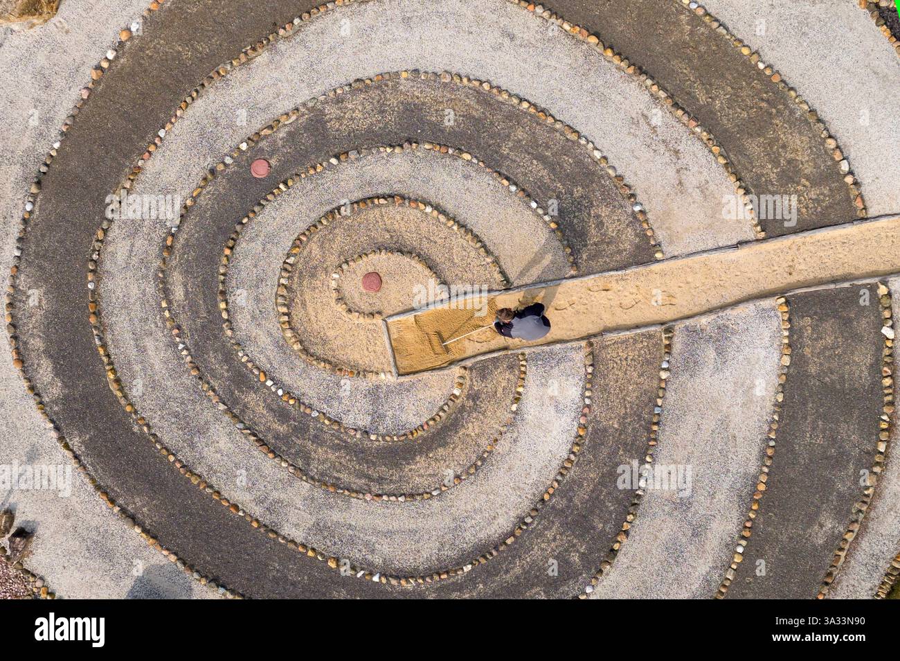 Boxberg, Germany. 14th Mar, 2025. A gardener works in the landscaped ...