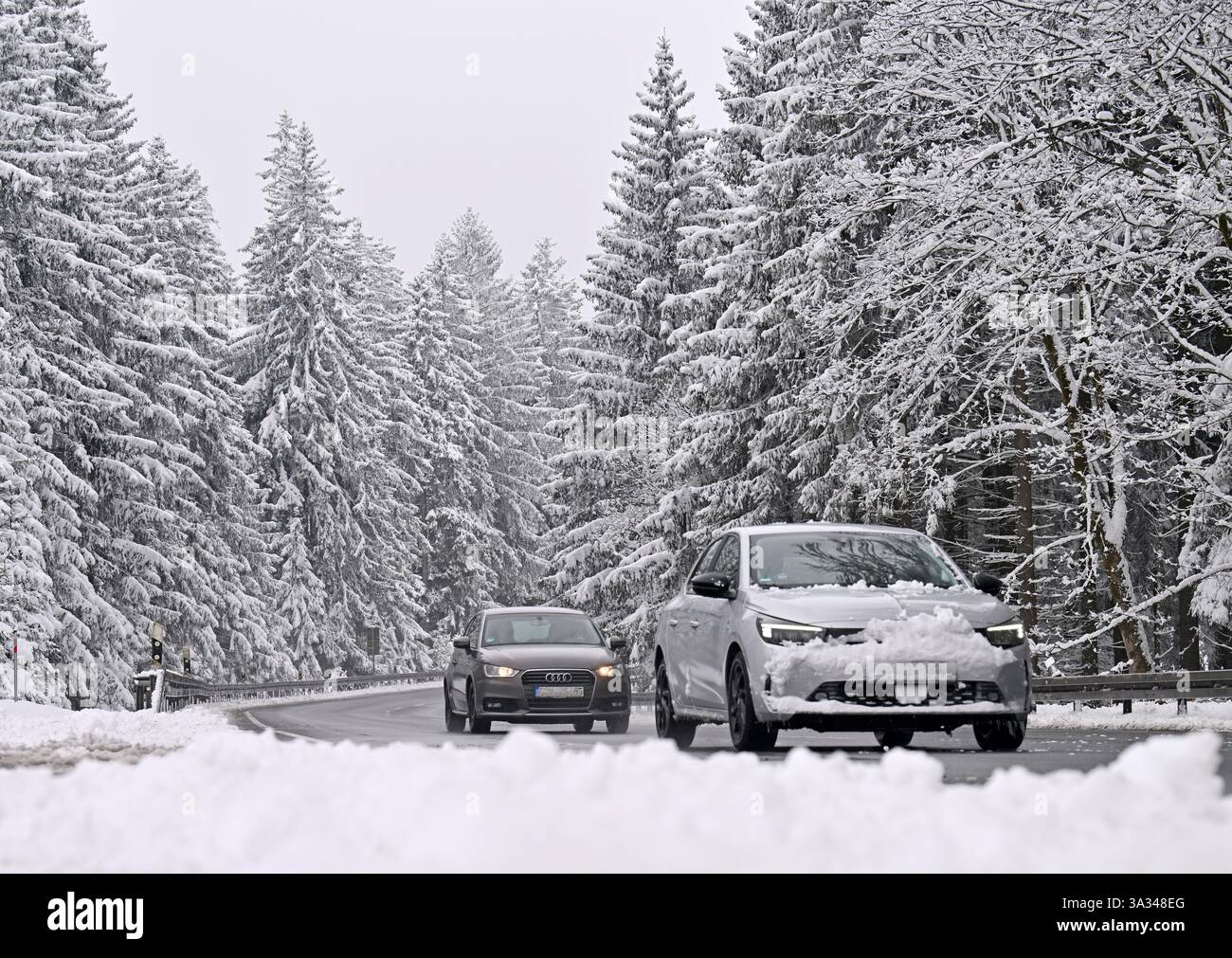 14 March 2025, Thuringia, Oberhof: Cars drive through a winter ...