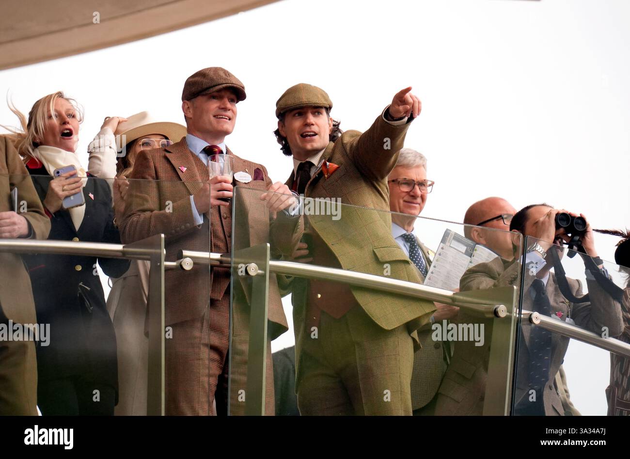 Henry Cavill (right) reacts as he watches the JCB Triumph Hurdle on day ...