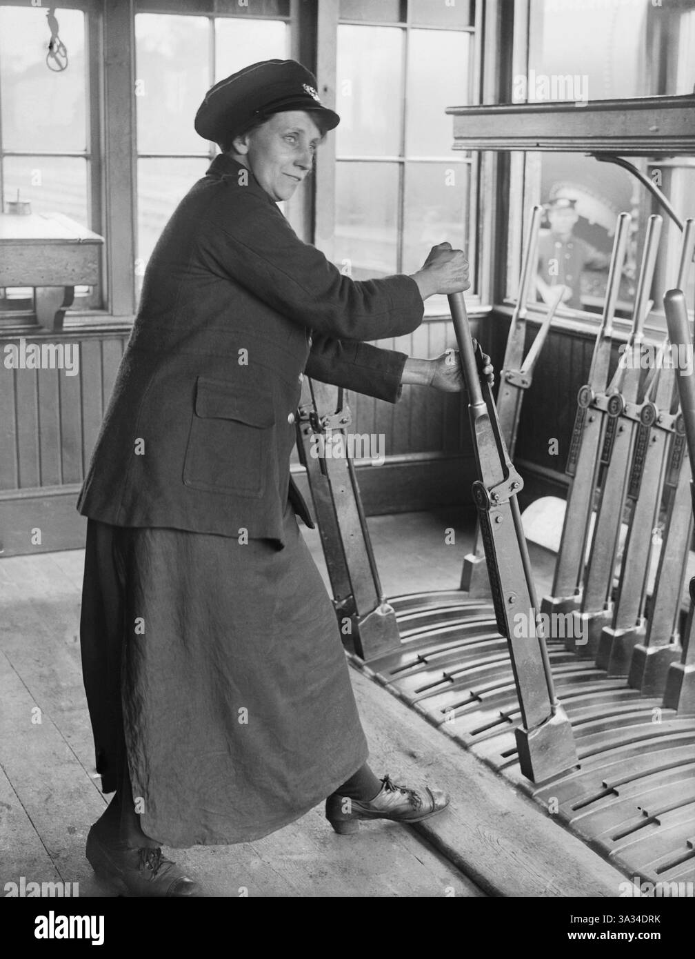 A woman railway worker operates the signals in a signal box on a siding ...