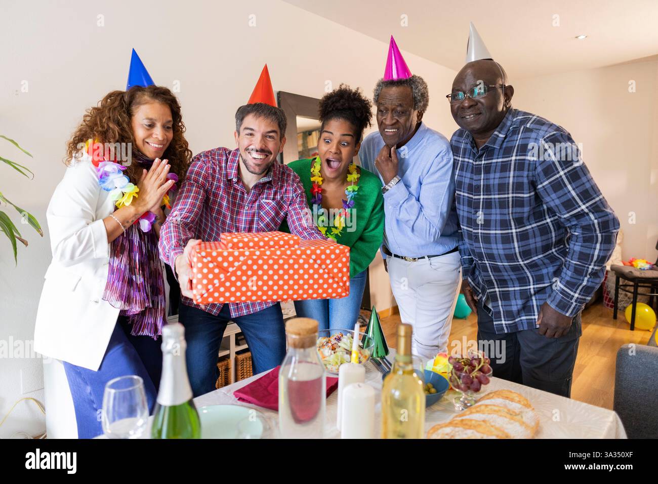 A group of friends joyfully celebrating a birthday. They wear festive ...