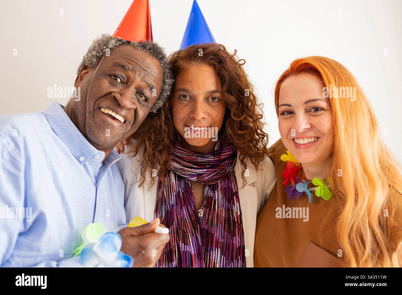 Three friends celebrate a special occasion, wearing colorful party hats ...