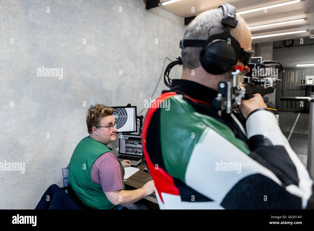 An athlete practices blind shooting, using auditory cues to aim A coach ...