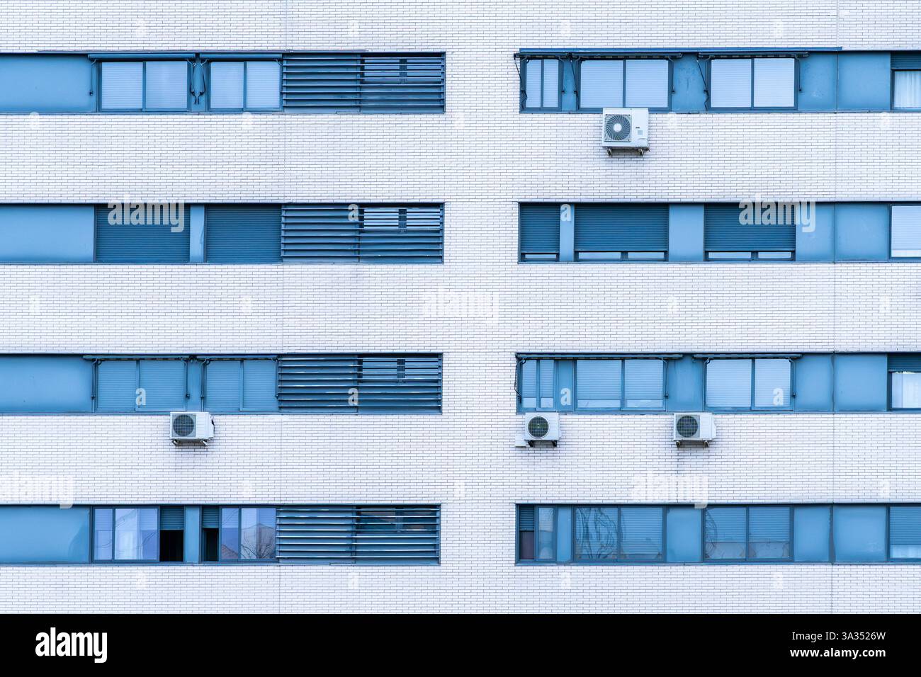 A modern urban facade featuring a white residential building with ...