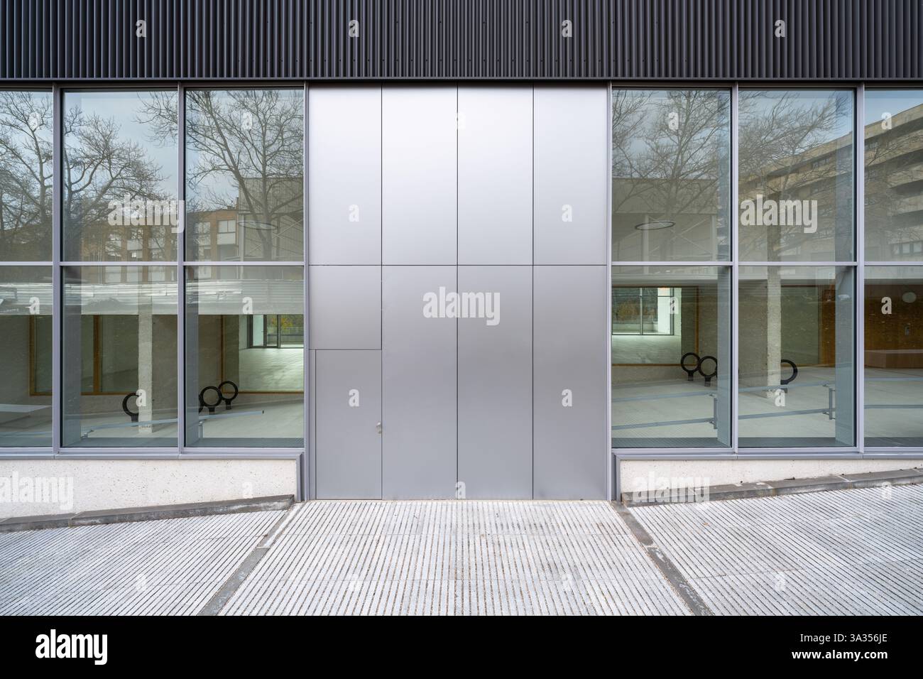 Sleek modern building facade with large windows reflects environmental ...