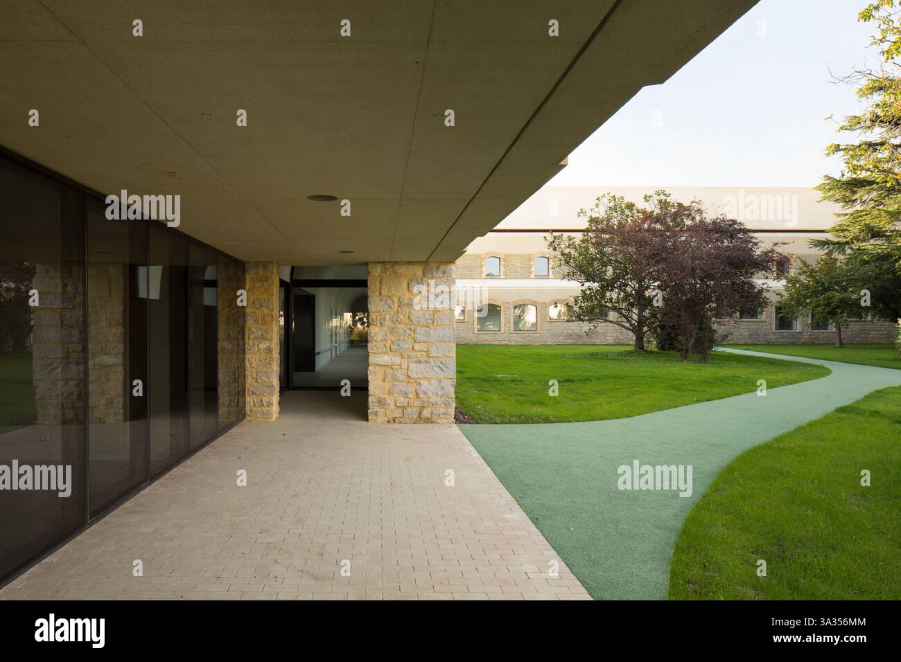 A modern architectural design featuring a stone hospital with large ...