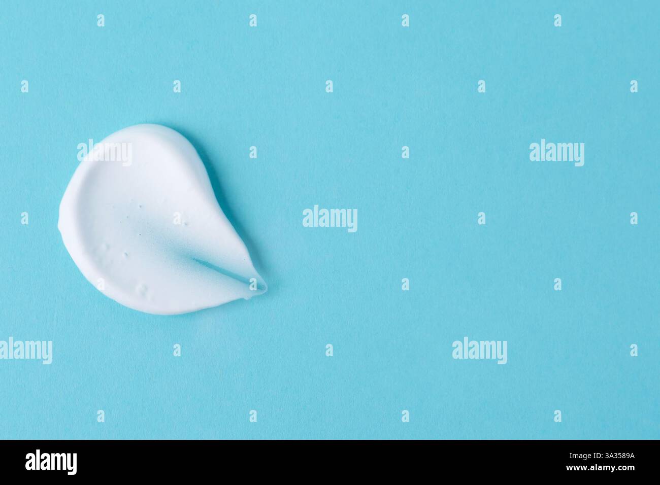 Sample of fluffy foam on light blue background, top view. Space for ...