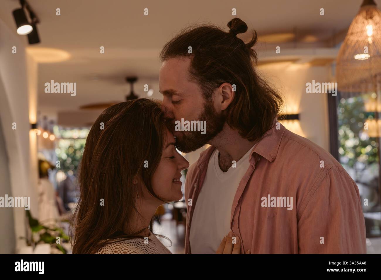 A couple enjoys an intimate moment in a cozy cafe, surrounded by warm ...