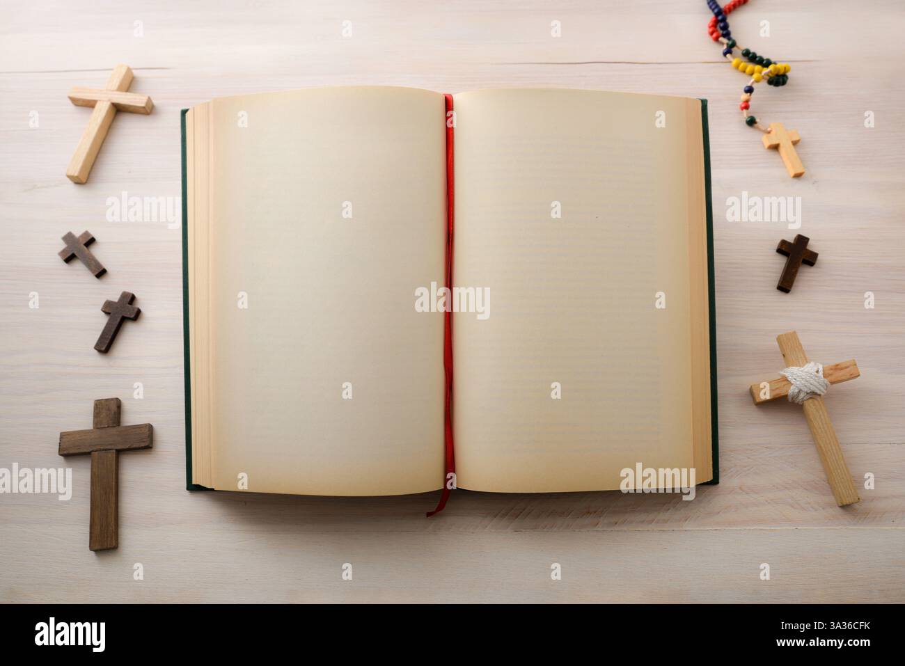 Open Bible with blank pages on a wooden table with wooden crosses of ...