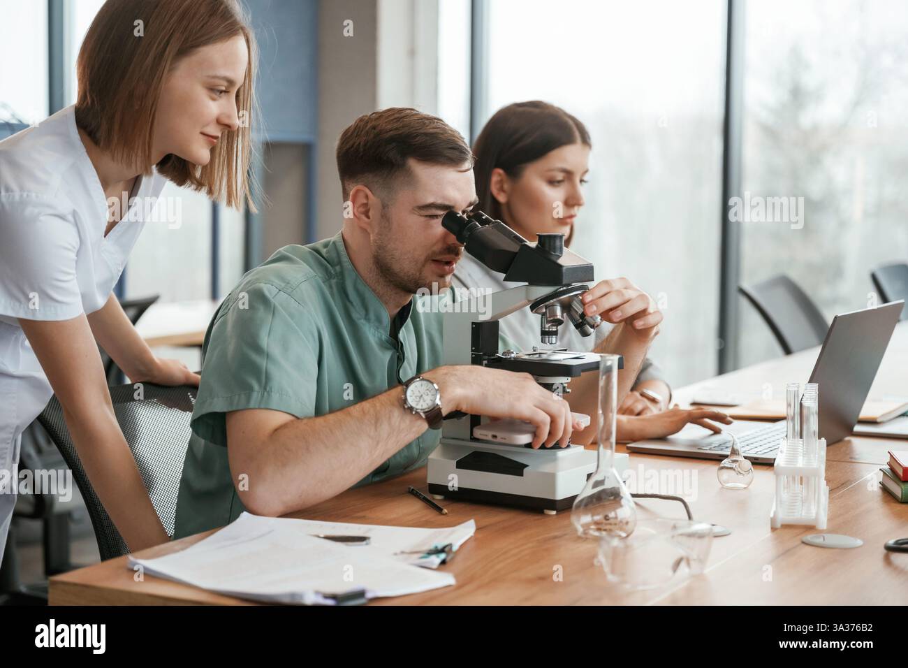 Laboratory with microscope. Group of doctors are together indoors Stock ...