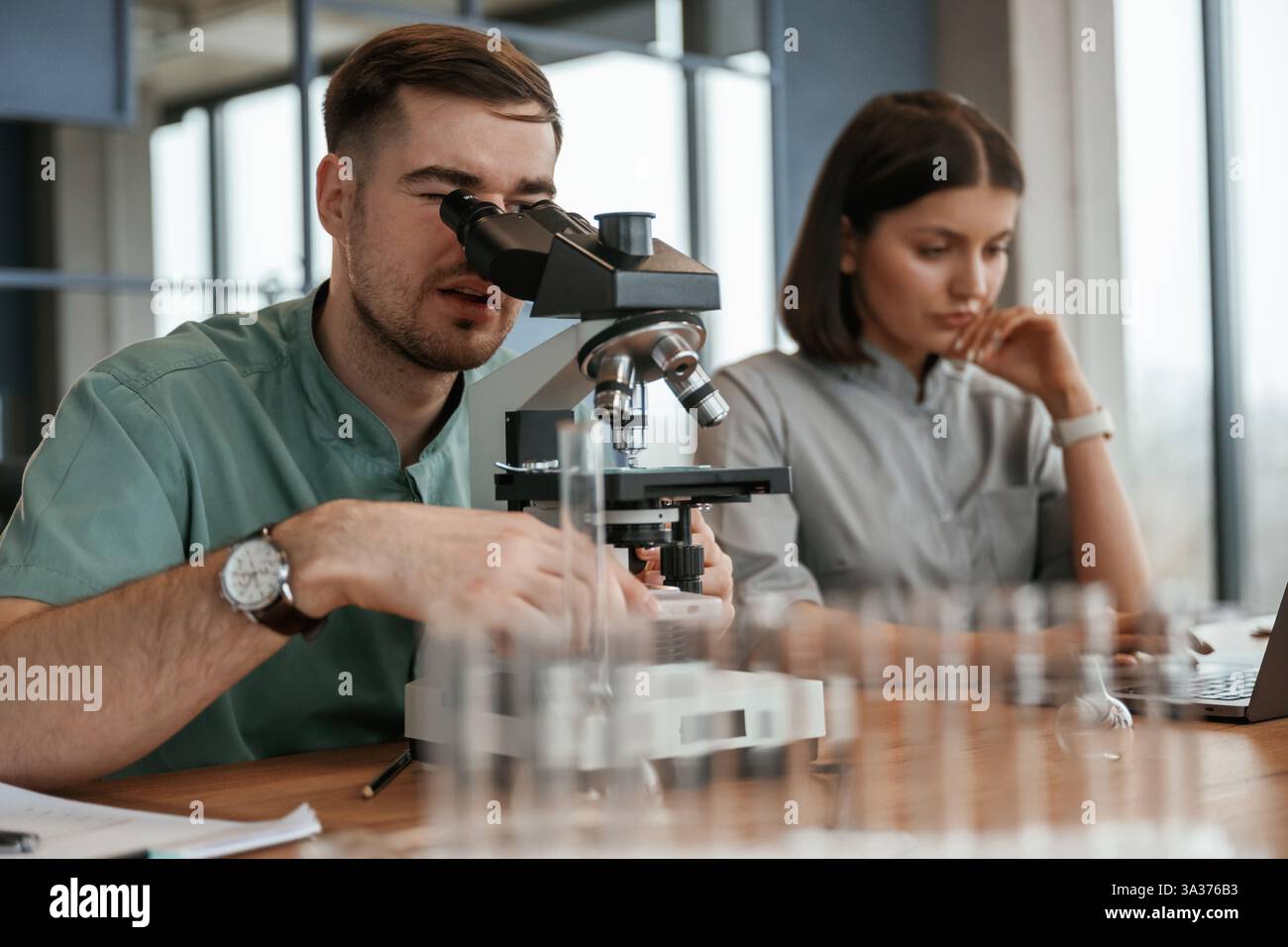 Laboratory with microscope. Group of doctors are together indoors Stock ...