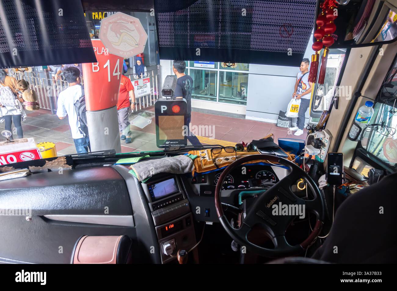 the interior of a shuttle bus, the driver's seat area. The steering ...