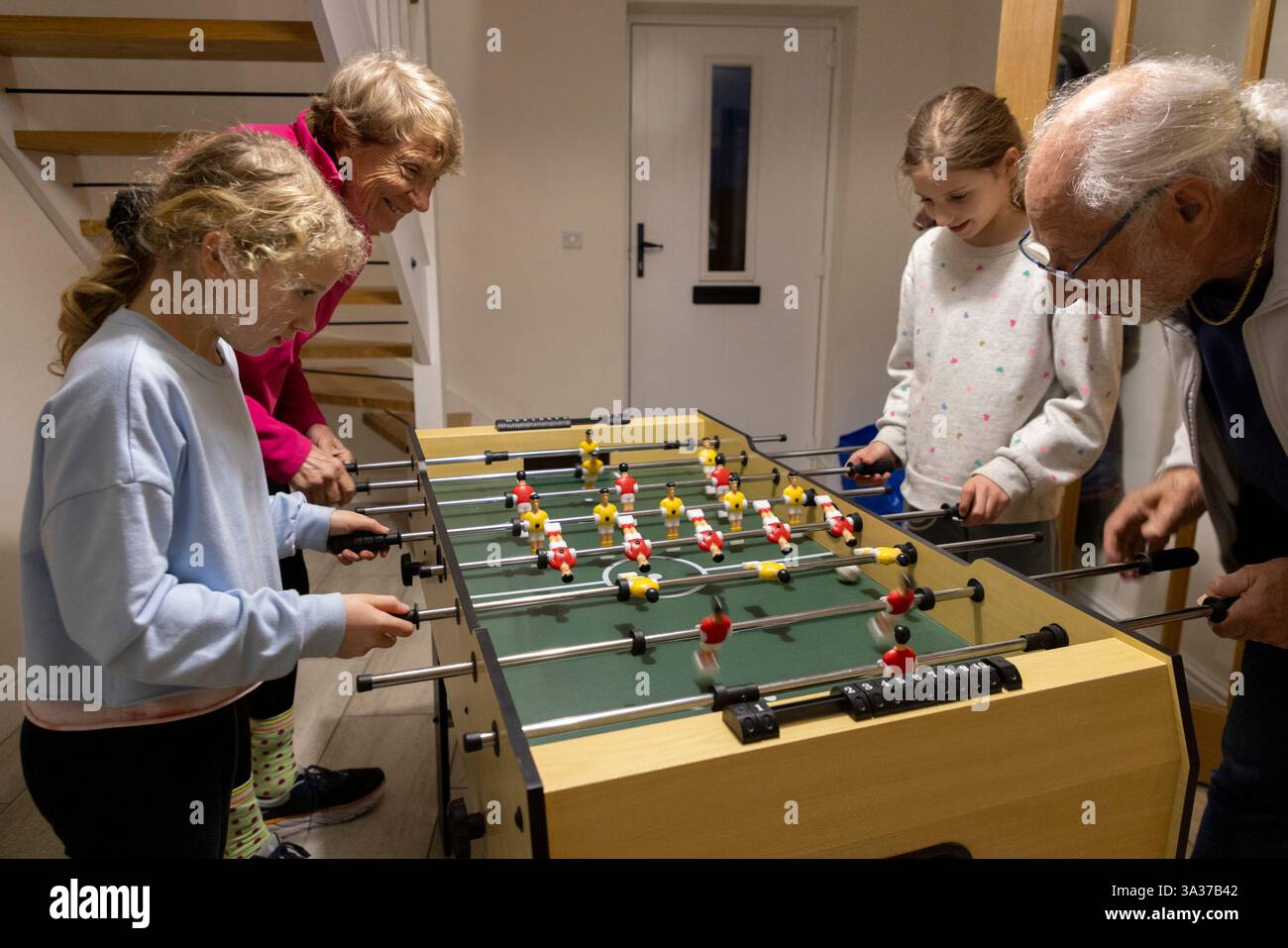 Grandparents (aged late 70s) and granddaughters (aged 7 and 9) play ...