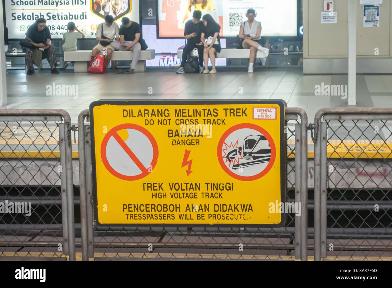 a warning sign in Malay and English, no crossing the train tracks, high ...