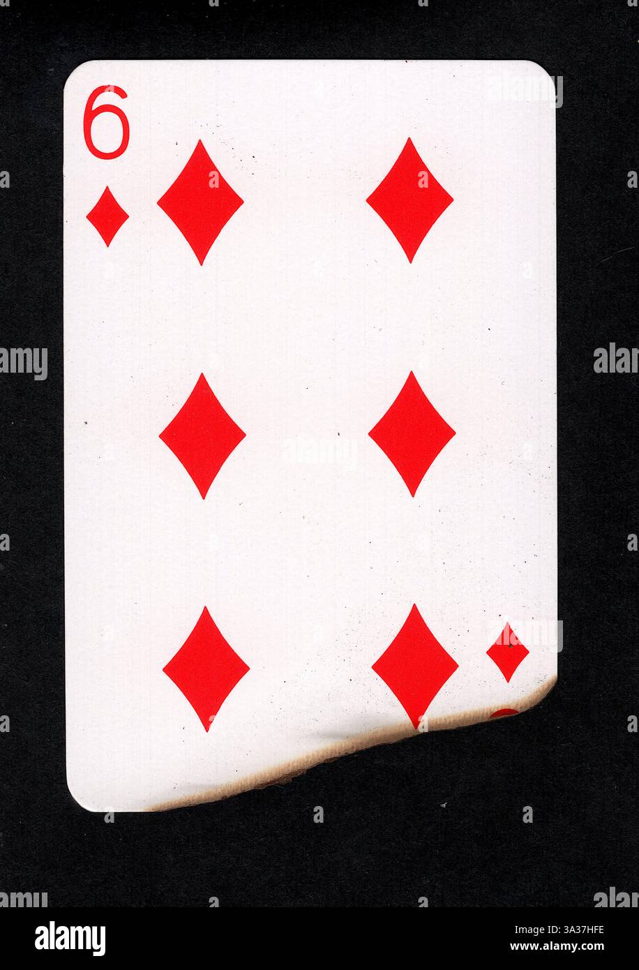 Partly burnt playing card in the suit of diamonds isolated on a black ...