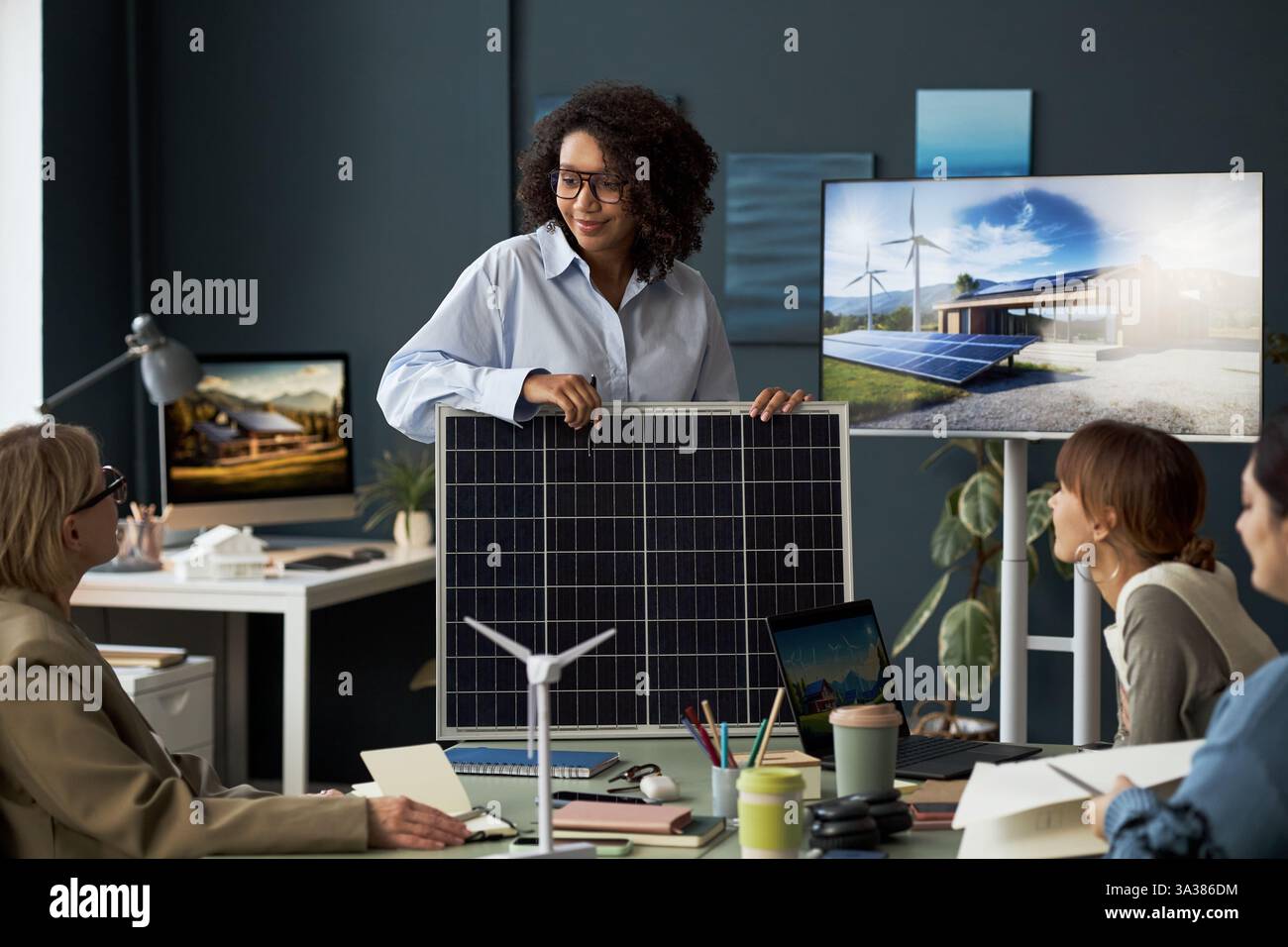 Woman Presenting Solar Panel To Colleagues Stock Photo - Alamy
