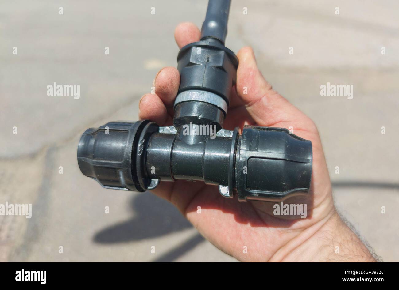 Polyethylene T connection for irrigation system. Gardener shows ...