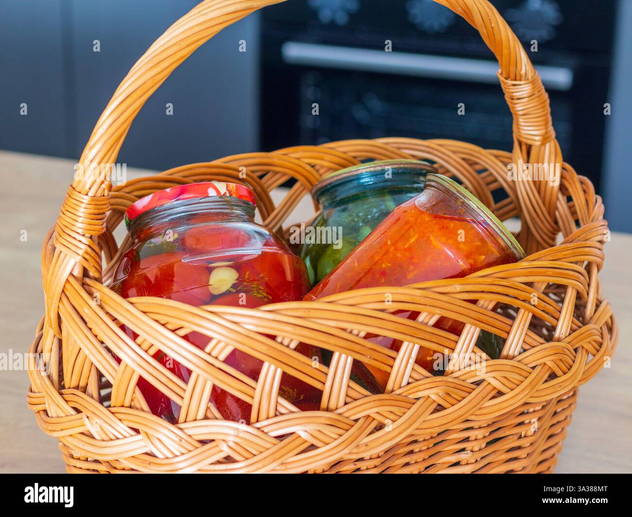 Jars with different types of pickles and preserves in a wicker basket ...