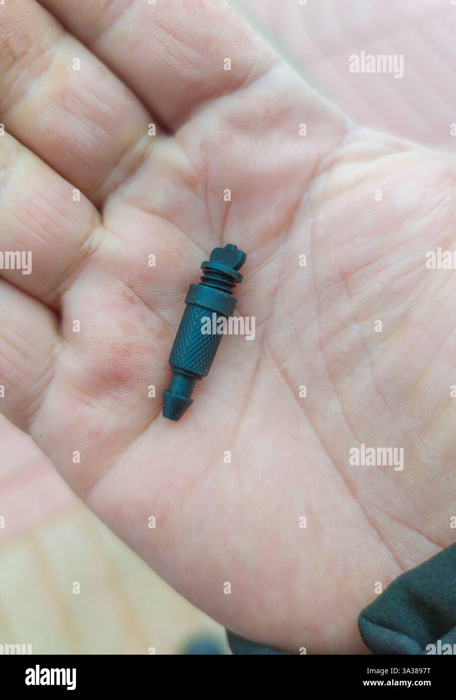 Adjustable dropper for irrigation system. Gardener shows watering ...