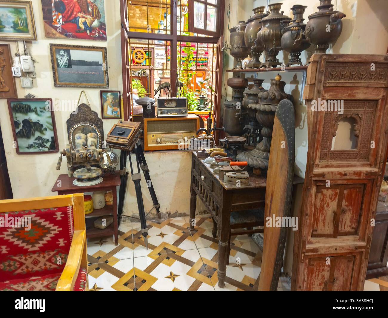 A cozy vintage room filled with antique items, including samovars, a ...