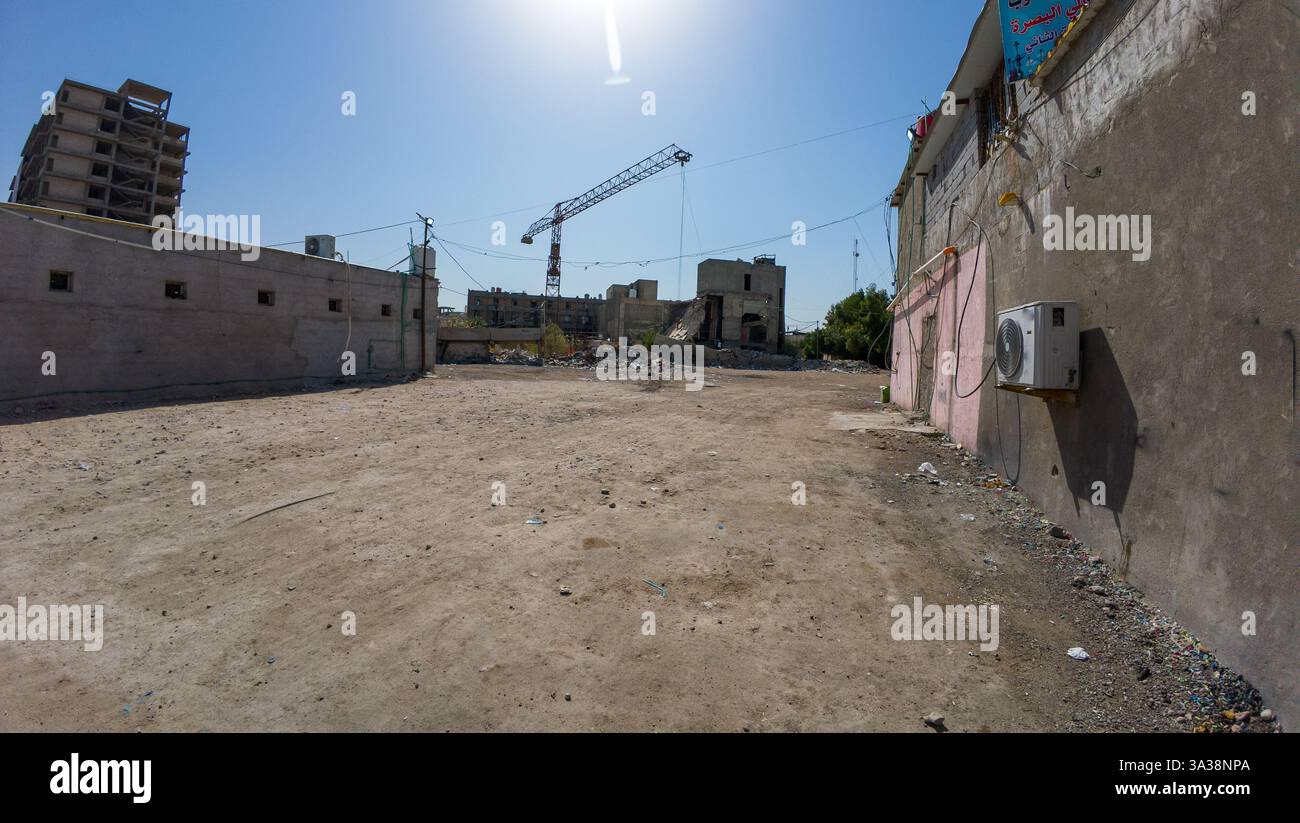 A wide-angle view of an empty construction site with debris, surrounded ...