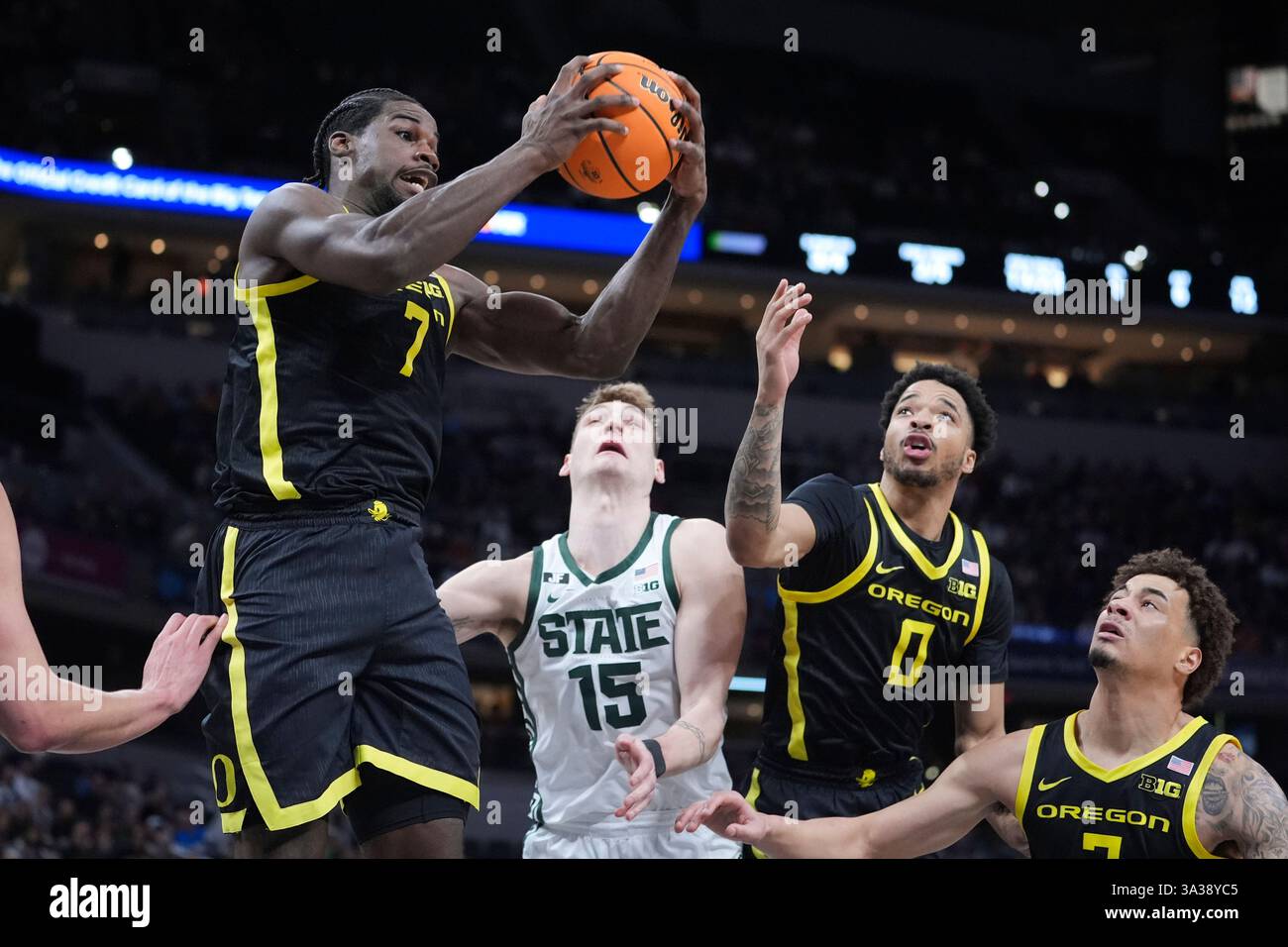 Oregon forward Supreme Cook (7) pulls down a rebound from Michigan ...
