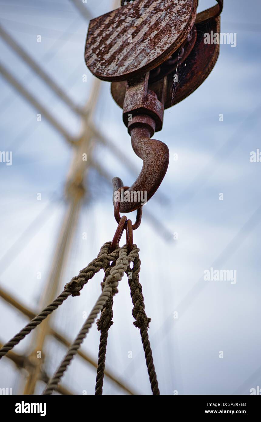 The rusty hook of an old harbor crane in the foreground, with the ...