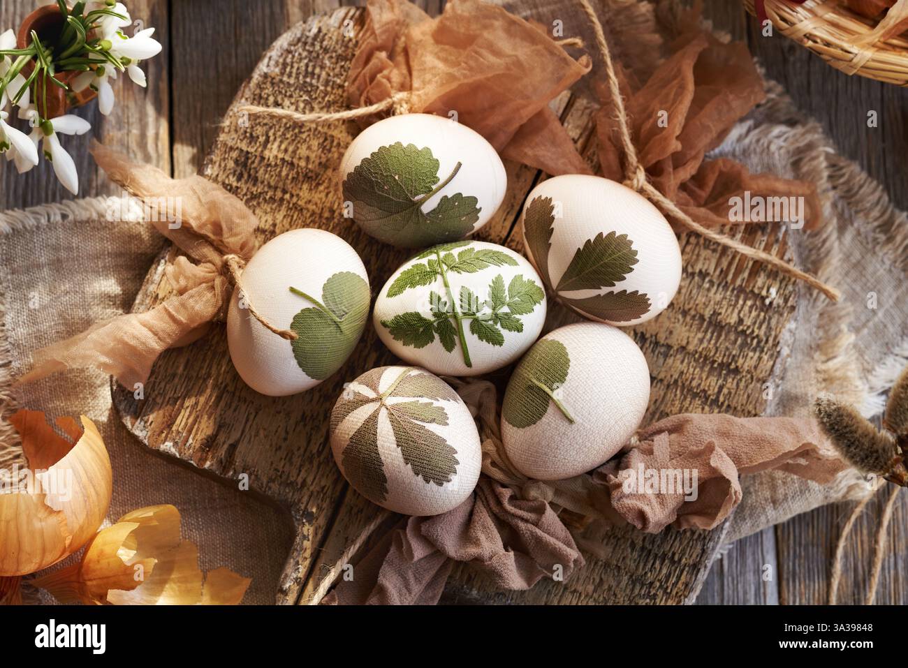 Several Easter eggs ready to be dyed with onion peels with a pattern of ...