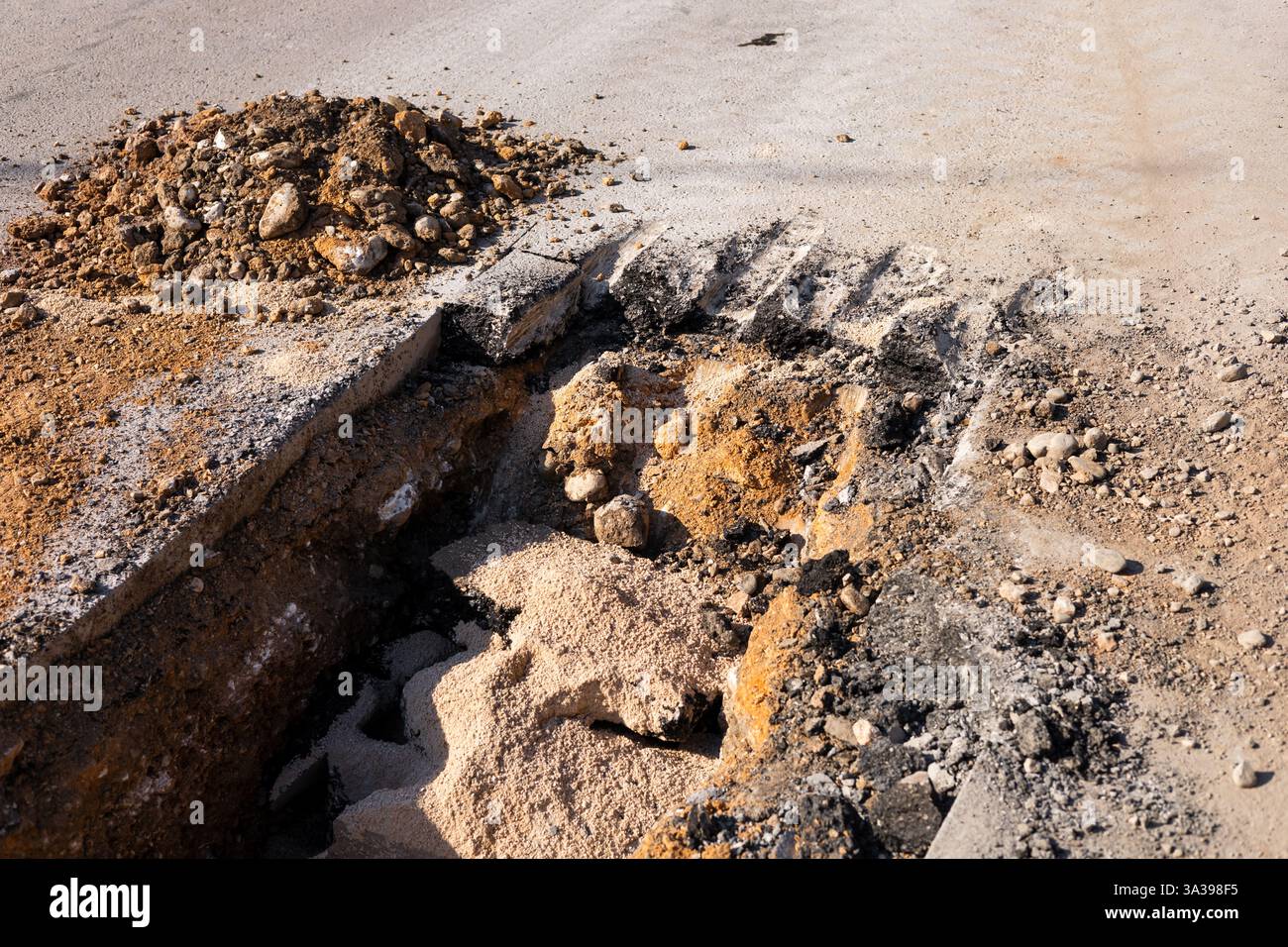 A road construction site displays an extensive trench freshly dug into ...