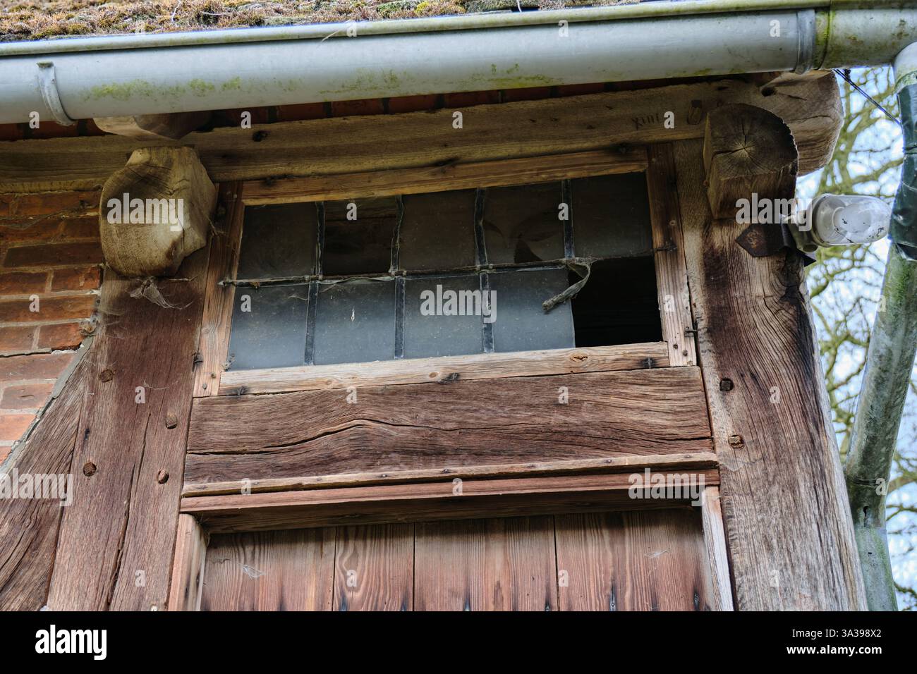 Aged wooden beams and a broken window of an old half-timbered watermill ...