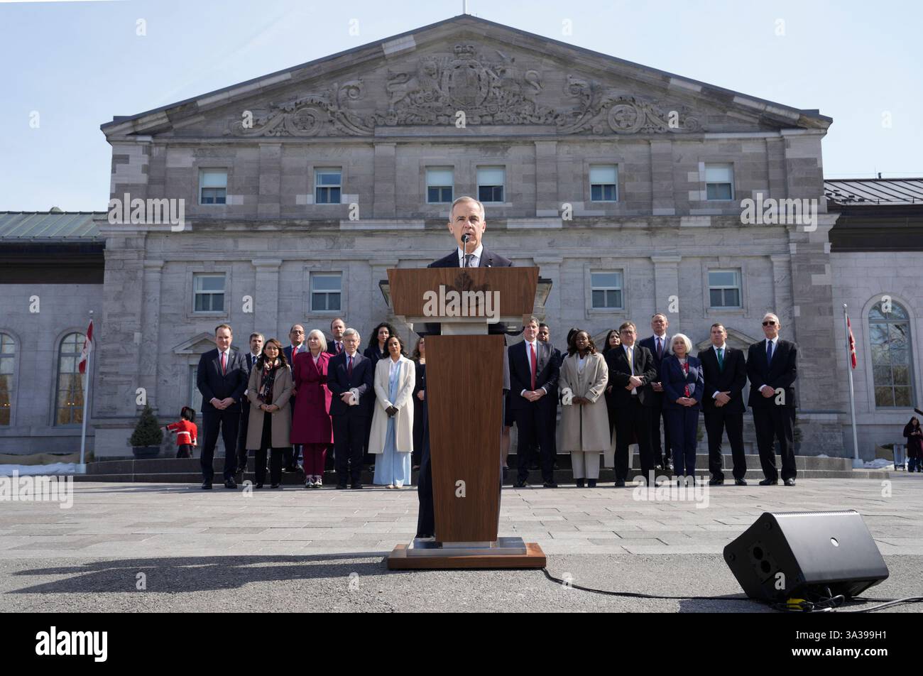 Prime Minister Mark Carney holds a press conference as members of his ...